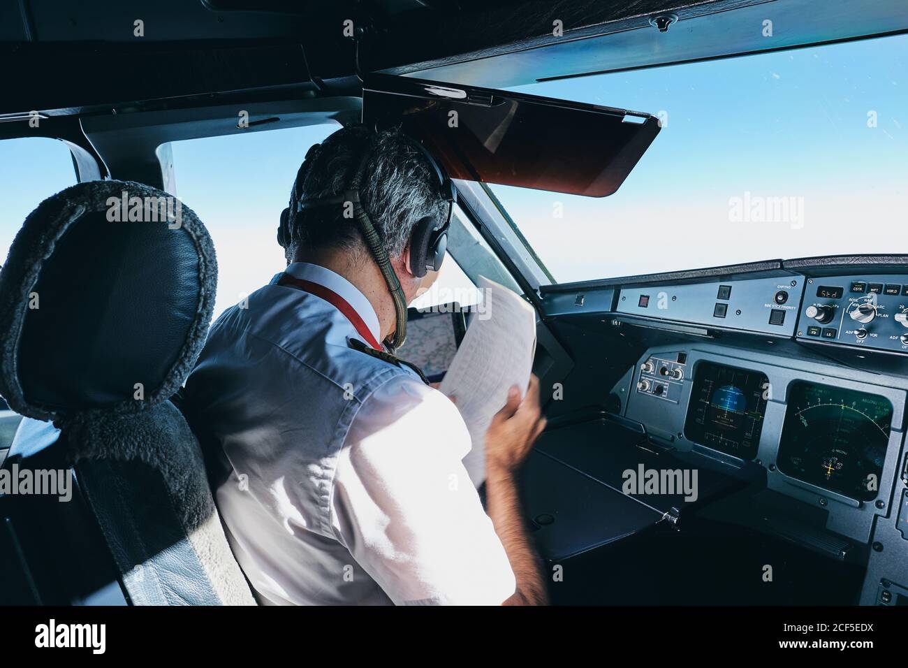 Captain checking flight document in airplane cockpit Stock Photo - Alamy