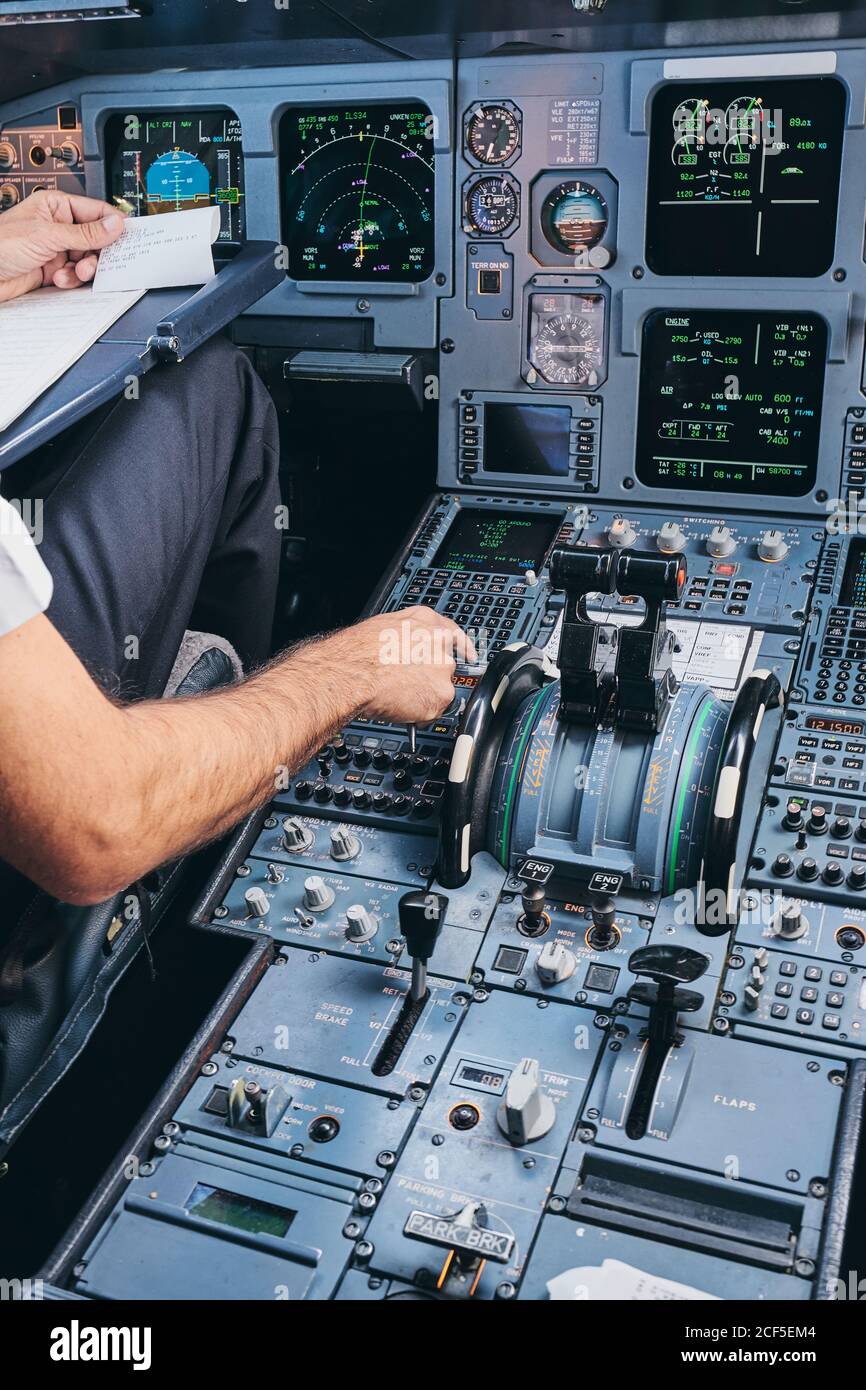 Pilot working with control console during flight Stock Photo - Alamy