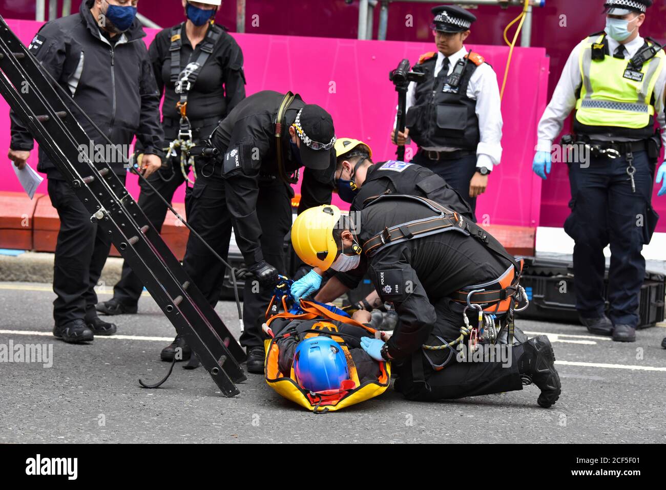 Police officers arrest a super glued protester from the roof a farm ...