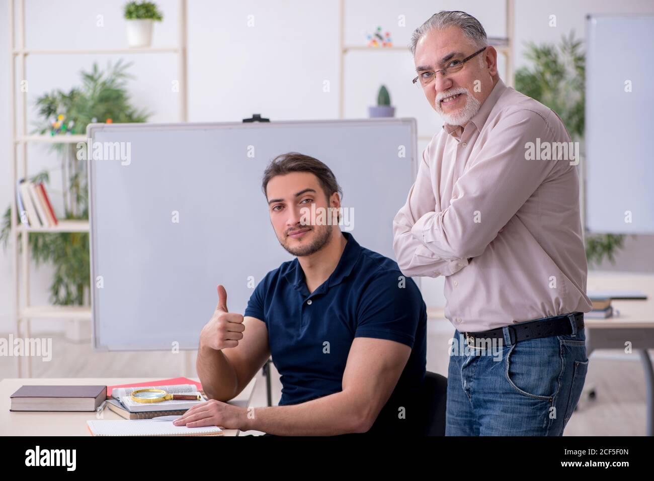 Old teacher and young student in the classroom Stock Photo - Alamy