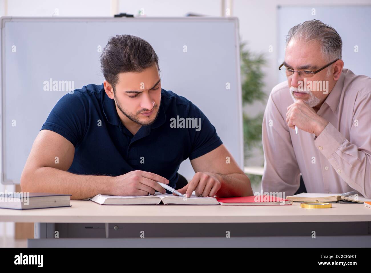 Old teacher and young student in the classroom Stock Photo - Alamy