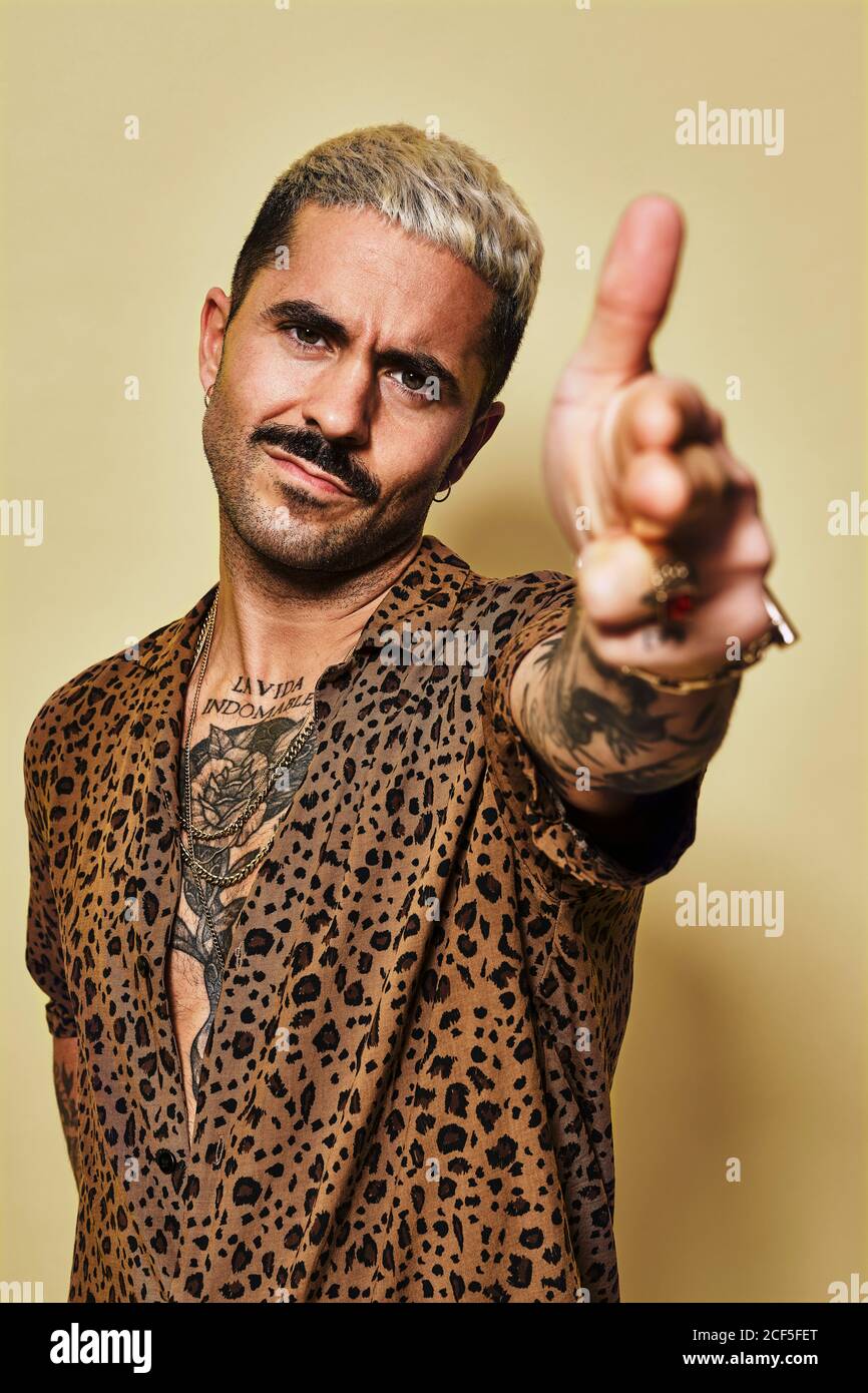 Adult bearded guy with stylish haircut and tattoo dressed in leopard ...