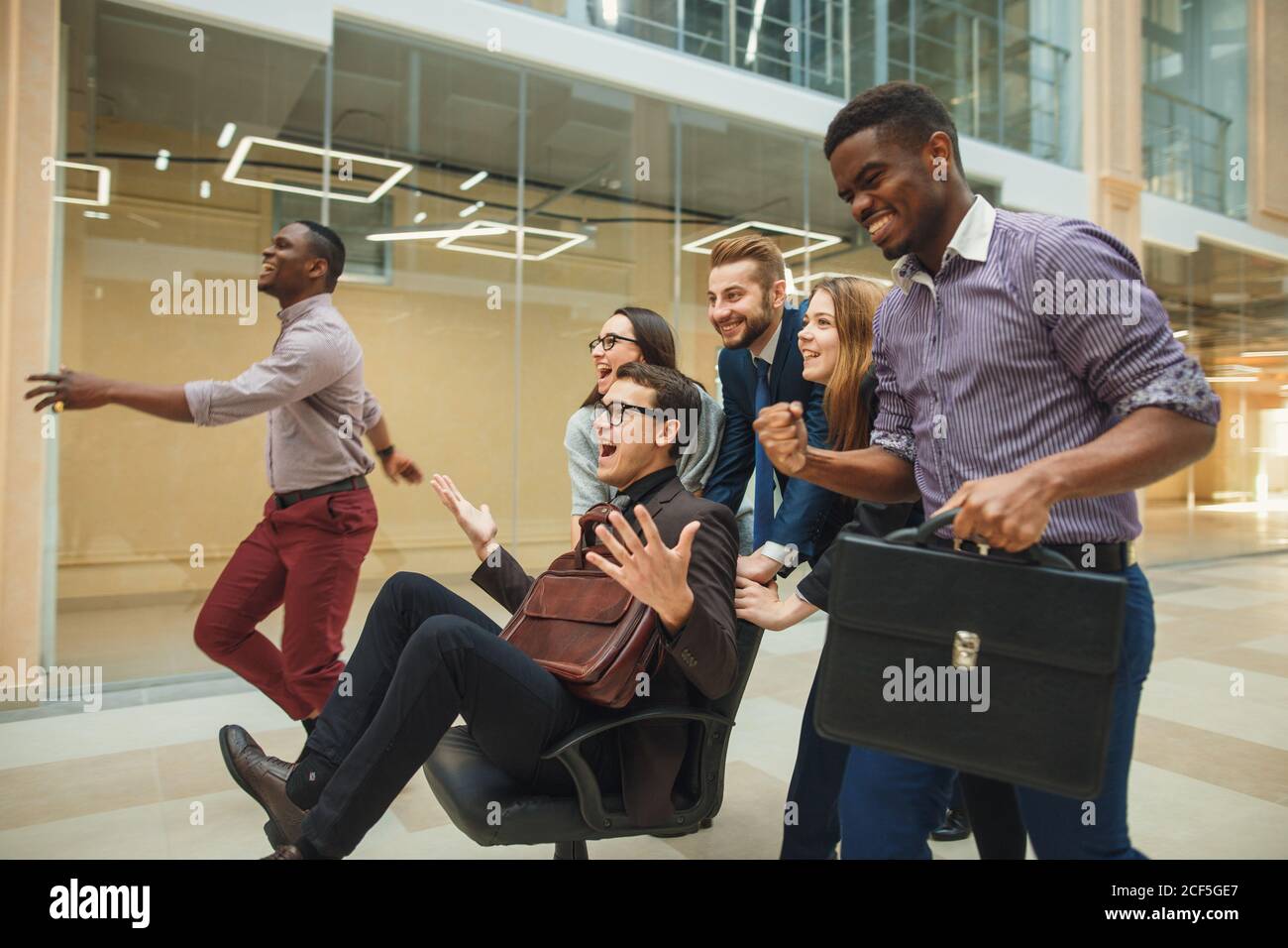 Successful excited Business people group team push colleague sitting in ...