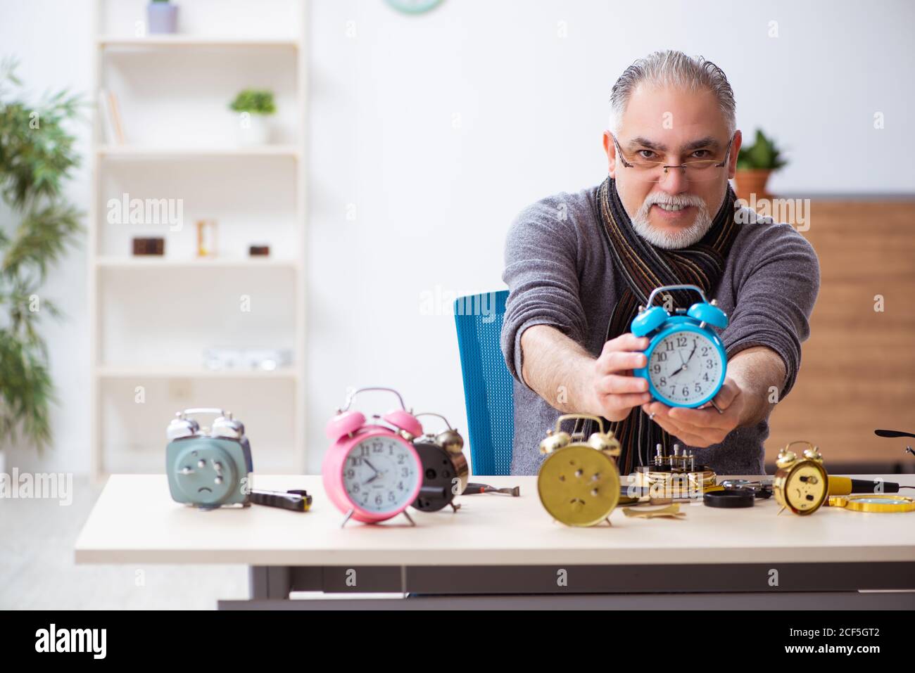 Old watchmaker working in the workshop Stock Photo - Alamy