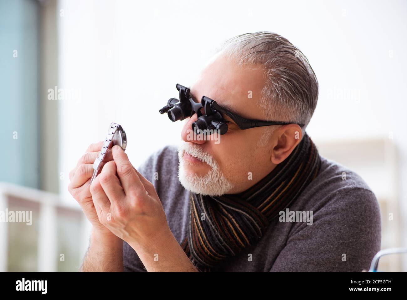 Old watchmaker working in the workshop Stock Photo - Alamy