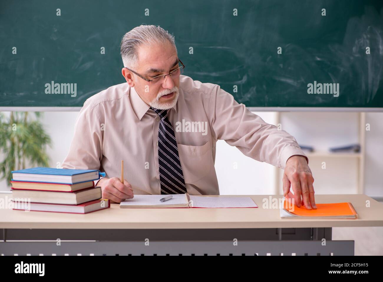 Old experienced teacher in the classroom Stock Photo - Alamy