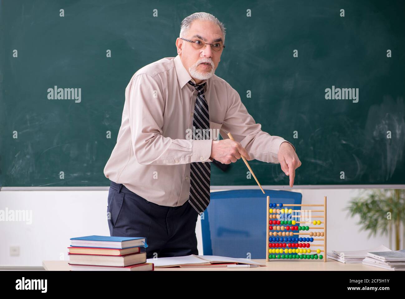 Old experienced teacher in the classroom Stock Photo - Alamy