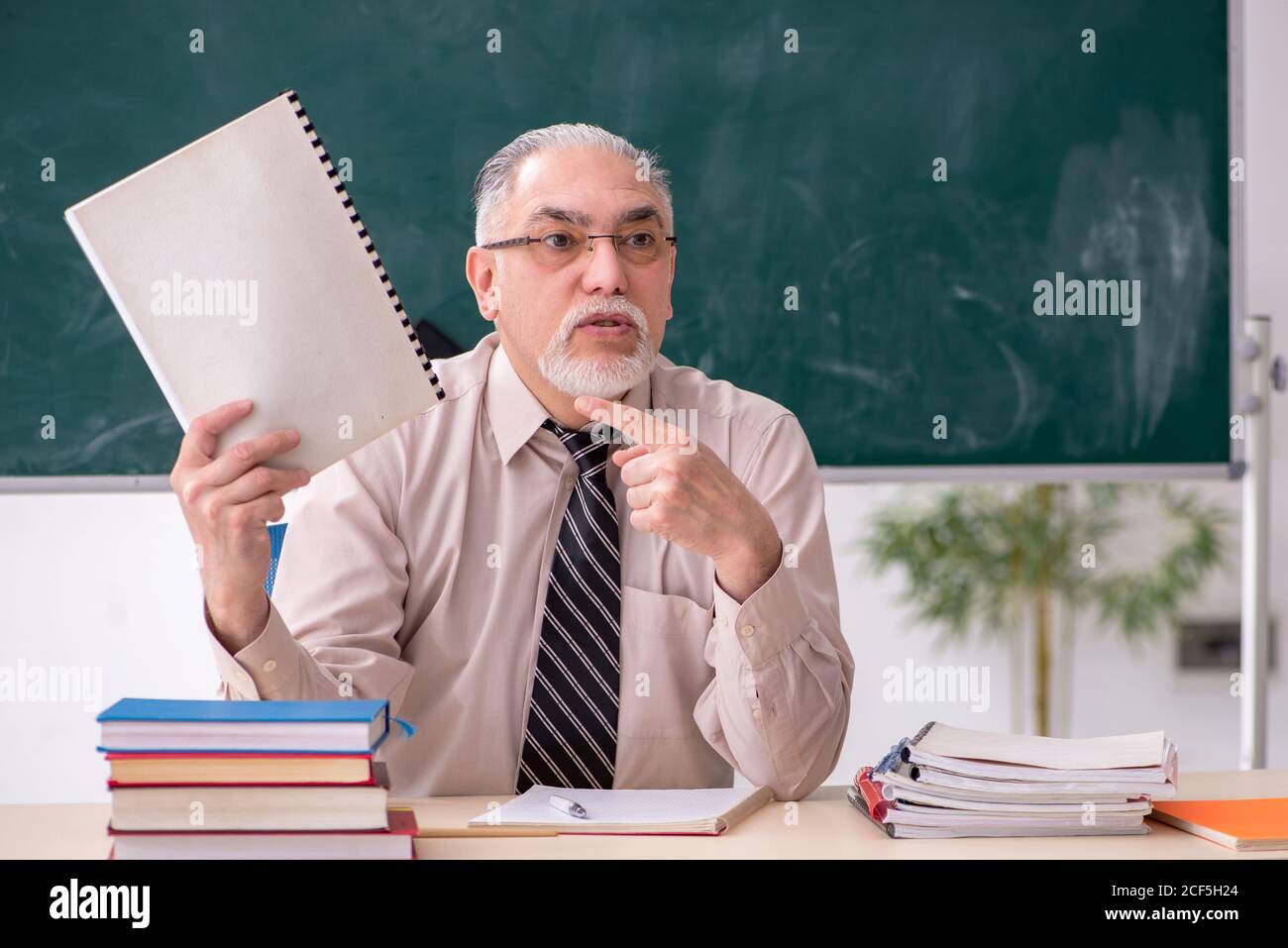 Old experienced teacher in the classroom Stock Photo - Alamy