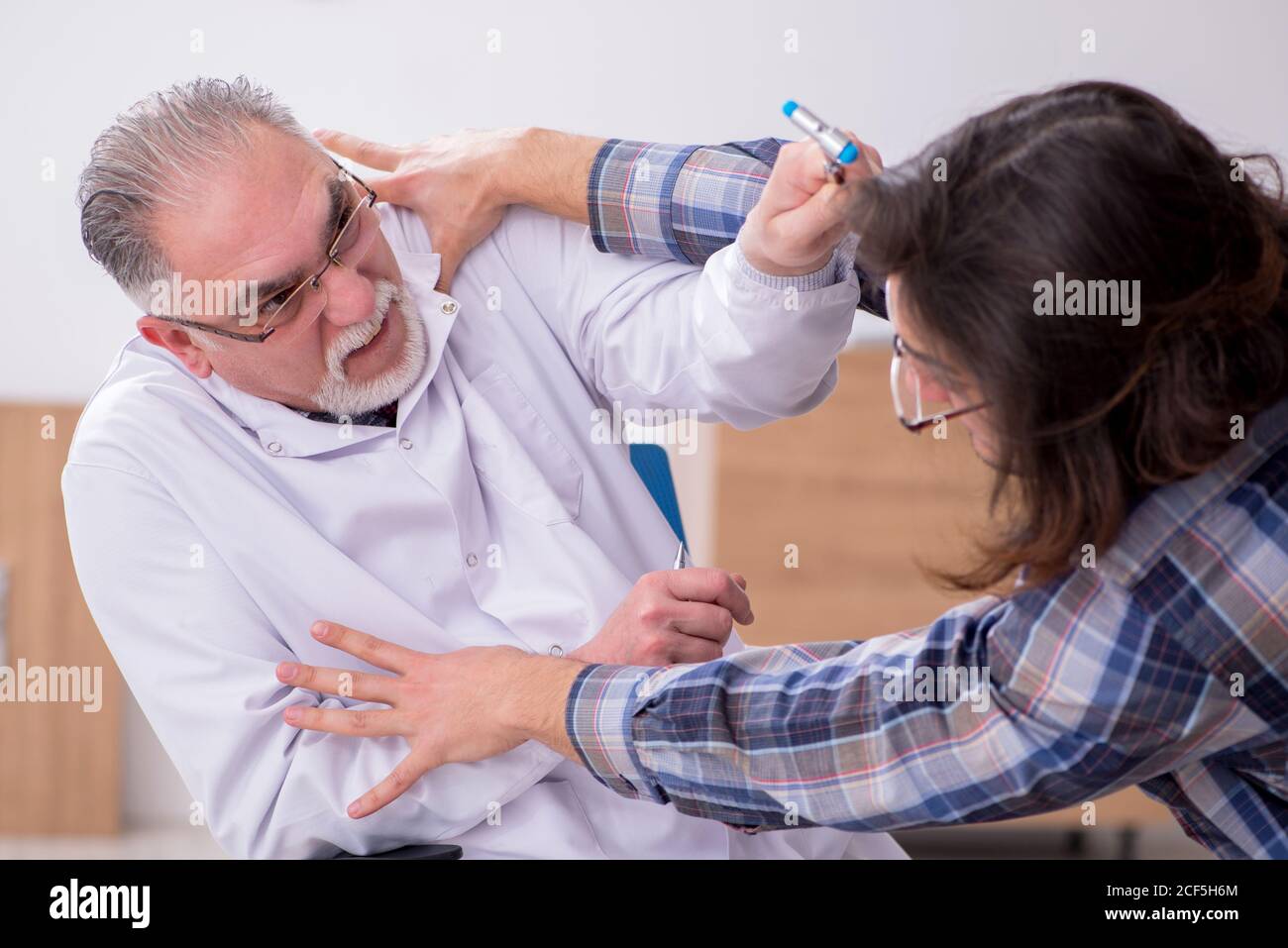 Young psychopath and experienced doctor in madhouse Stock Photo - Alamy
