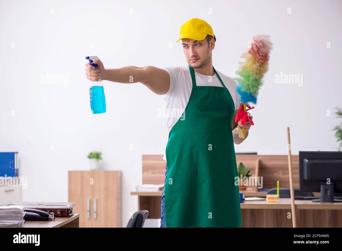Young contractor cleaning the office Stock Photo - Alamy
