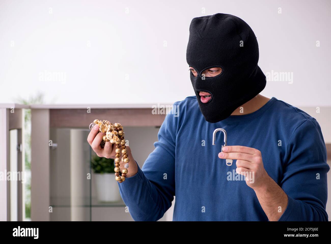 Robber stealing valuable things from the house Stock Photo - Alamy