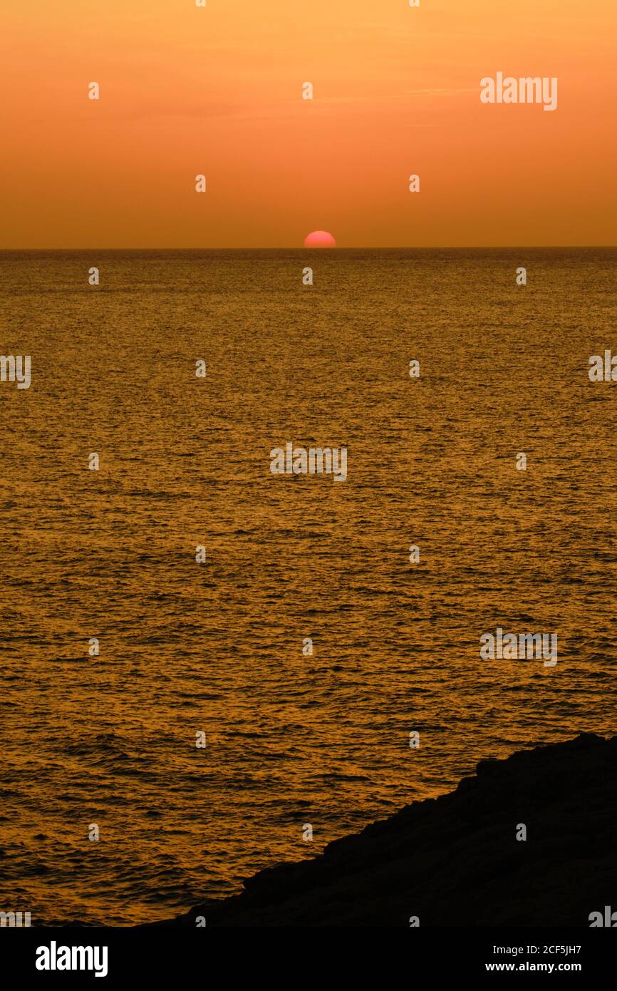 Amazing golden sunset over dark ocean Stock Photo - Alamy