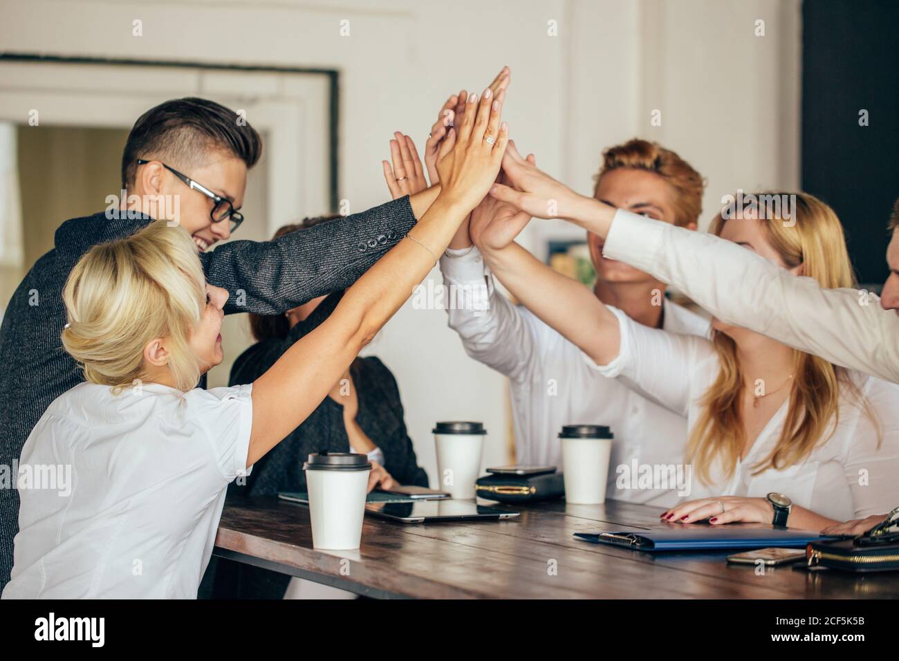 Happy successful multiracial business team giving a high fives gesture ...