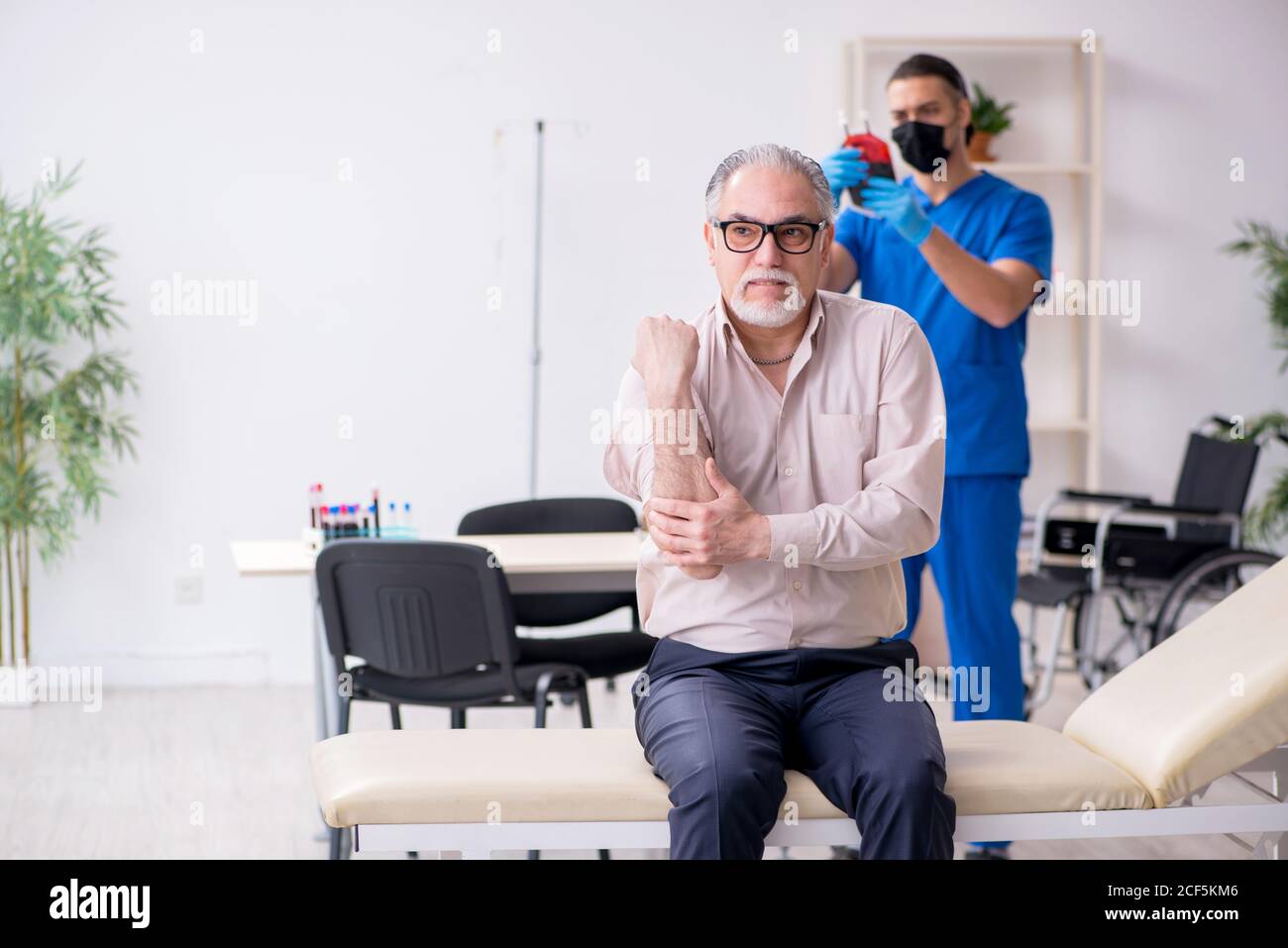 Old patient visiting young doctor in blood sampling concept Stock Photo ...