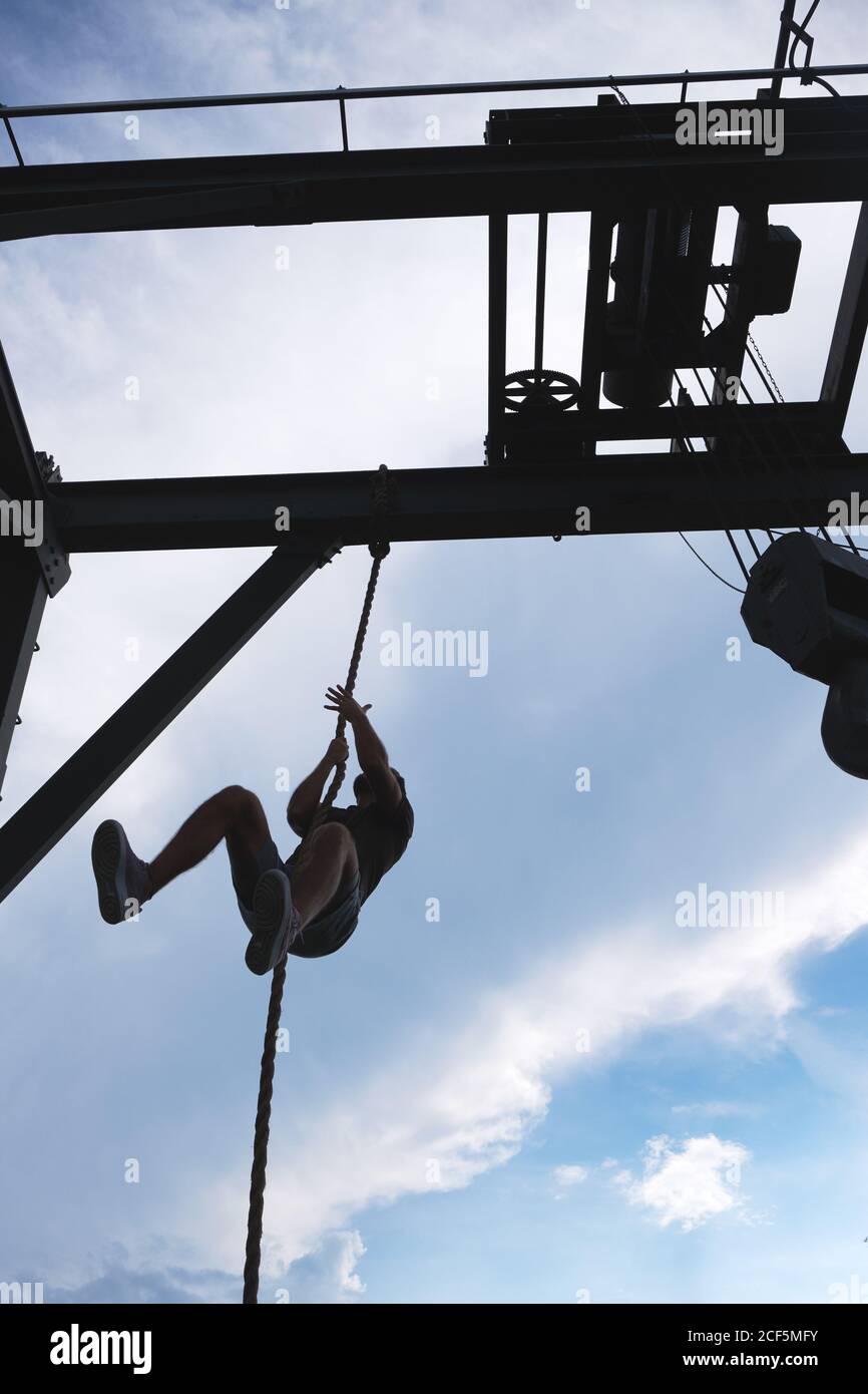 anonymous man climbing rope in outdoor gym Stock Photo - Alamy