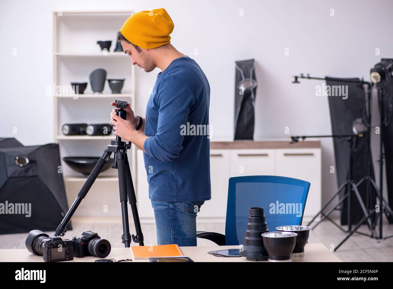 Young photographer working in the studio Stock Photo - Alamy