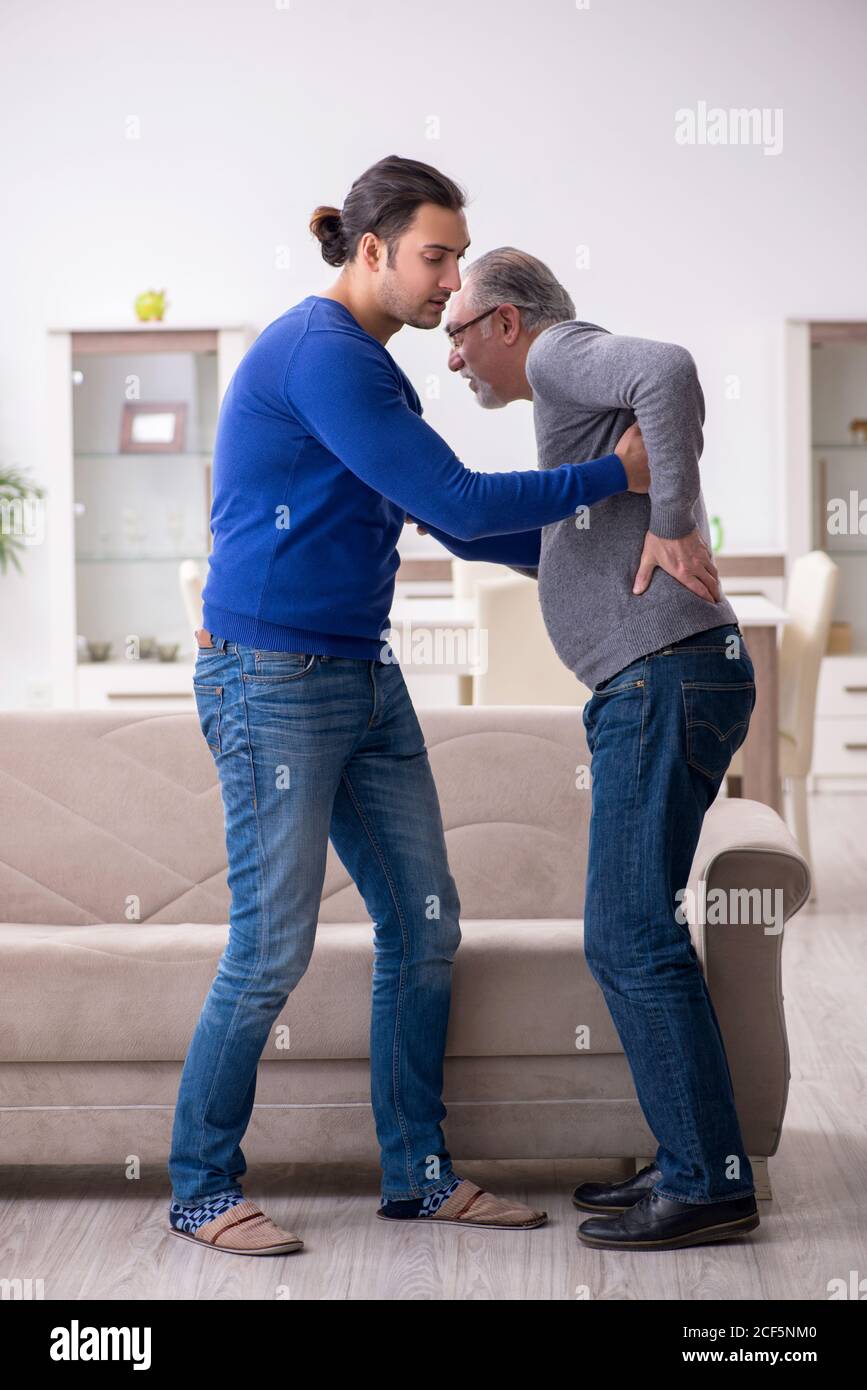 Young man looking after his sick father at home Stock Photo - Alamy