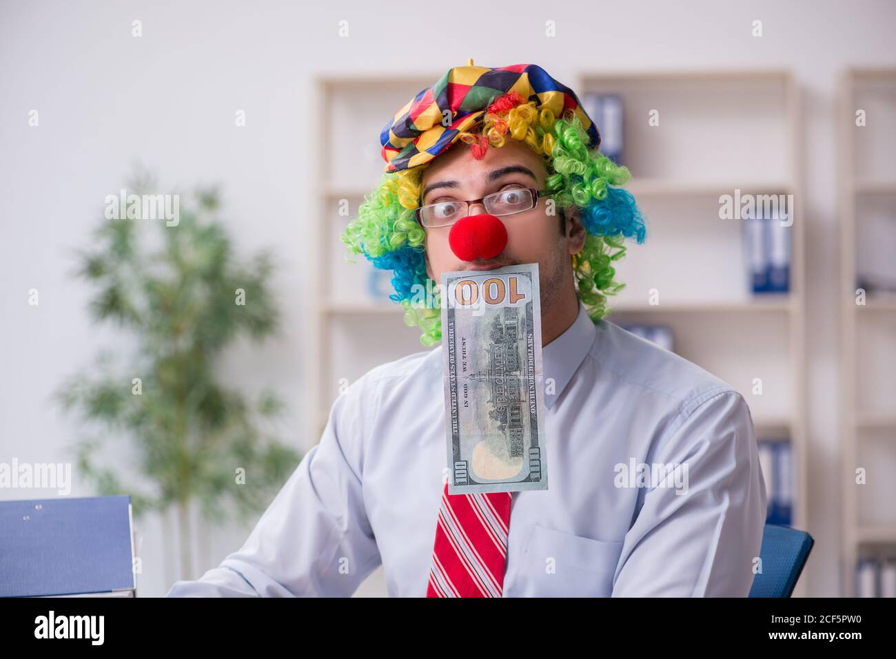 Funny employee clown working in the office room Stock Photo - Alamy