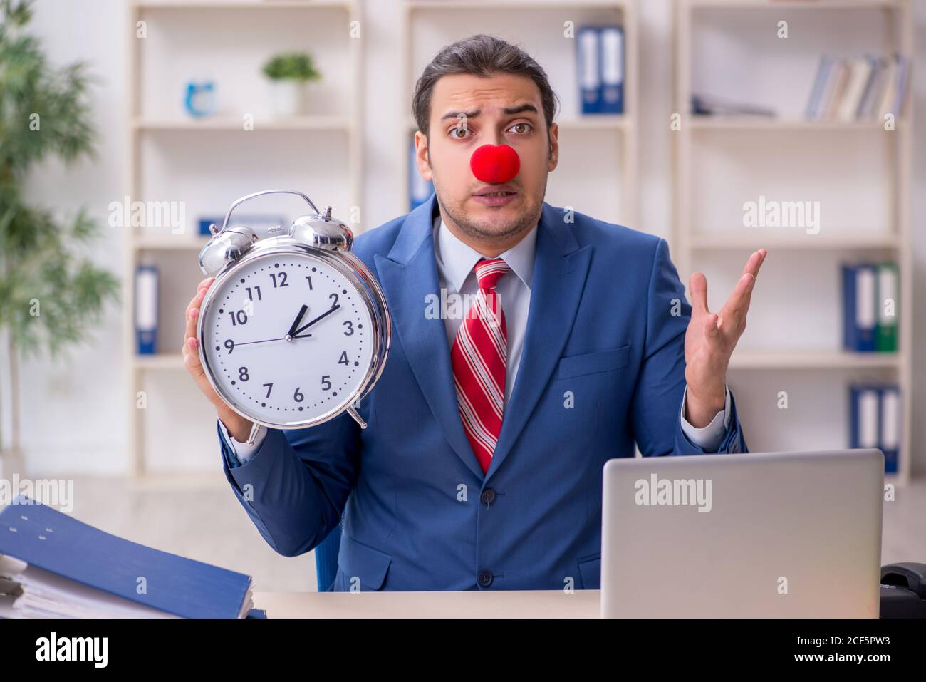 Funny employee clown working in the office room Stock Photo - Alamy