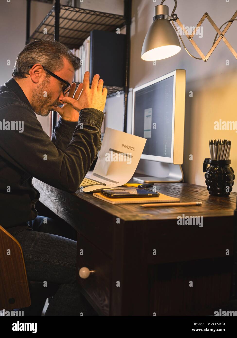 worried and overwhelmed man at home desk with computer with notes ...