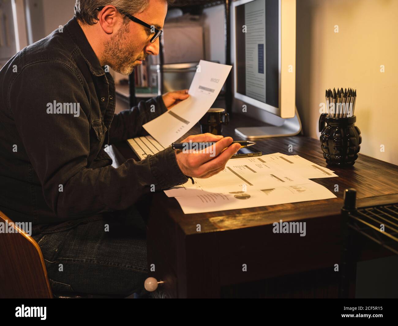 worried and overwhelmed man at home desk with computer with notes ...