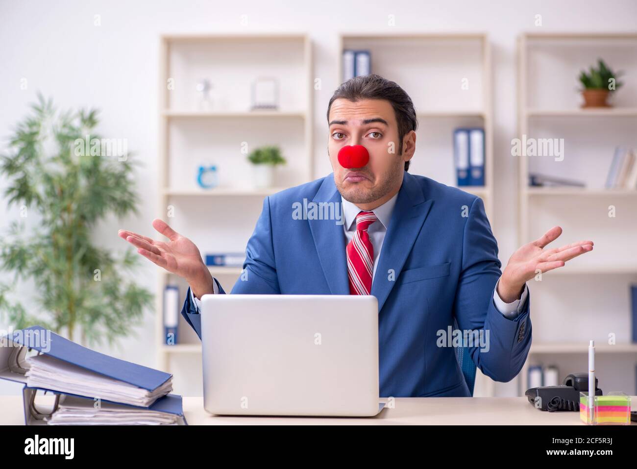 Funny employee clown working in the office room Stock Photo - Alamy