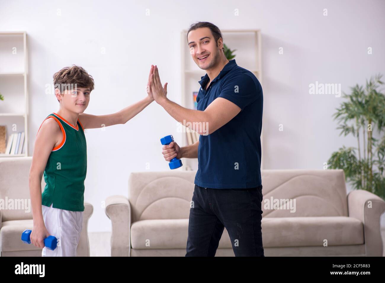 Father and son doing sport exercises at home Stock Photo - Alamy
