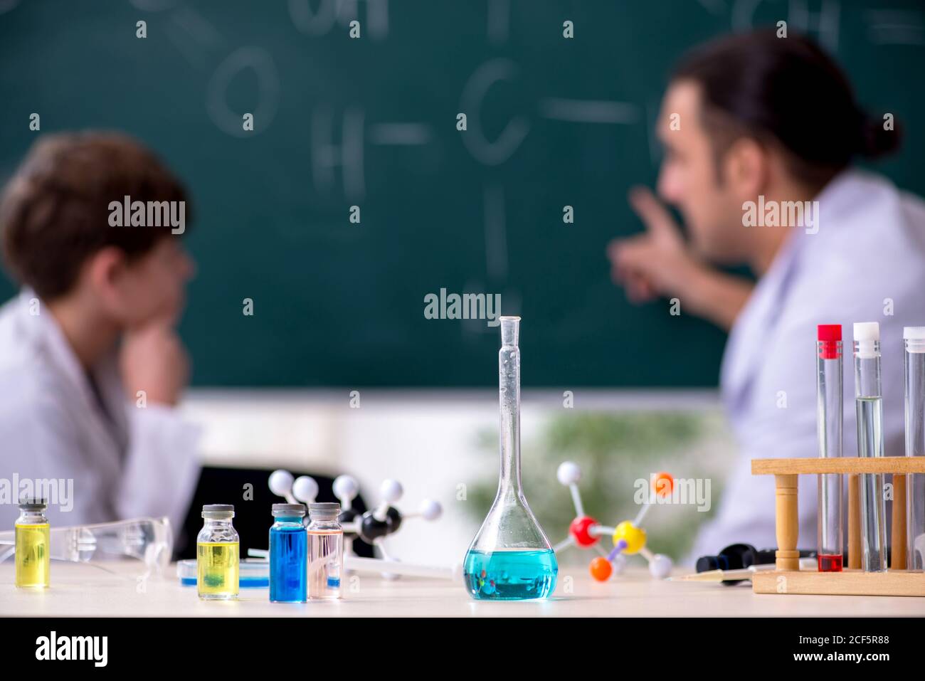 Young chemistry teacher and schoolboy in classroom Stock Photo - Alamy