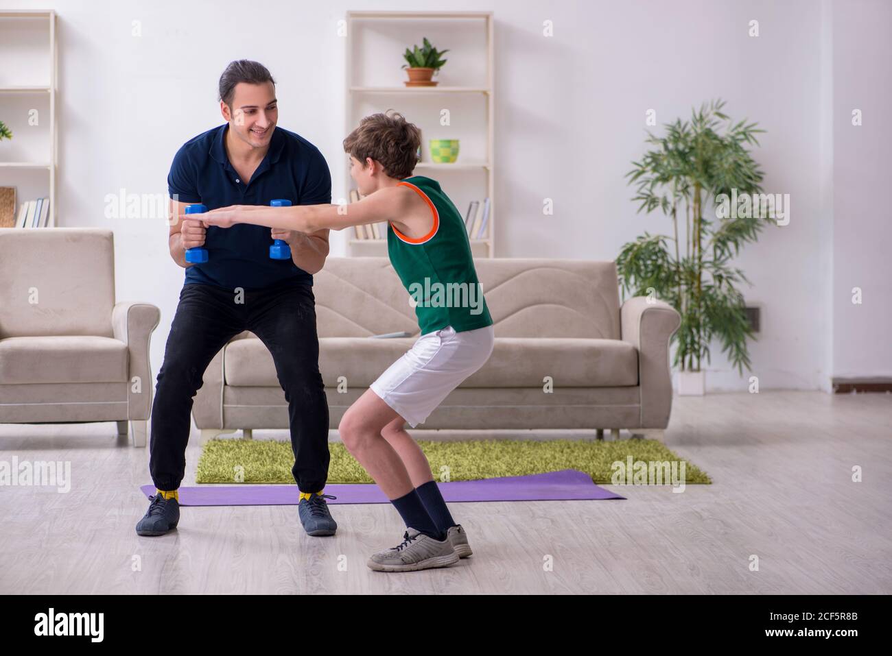 Father and son doing sport exercises at home Stock Photo - Alamy