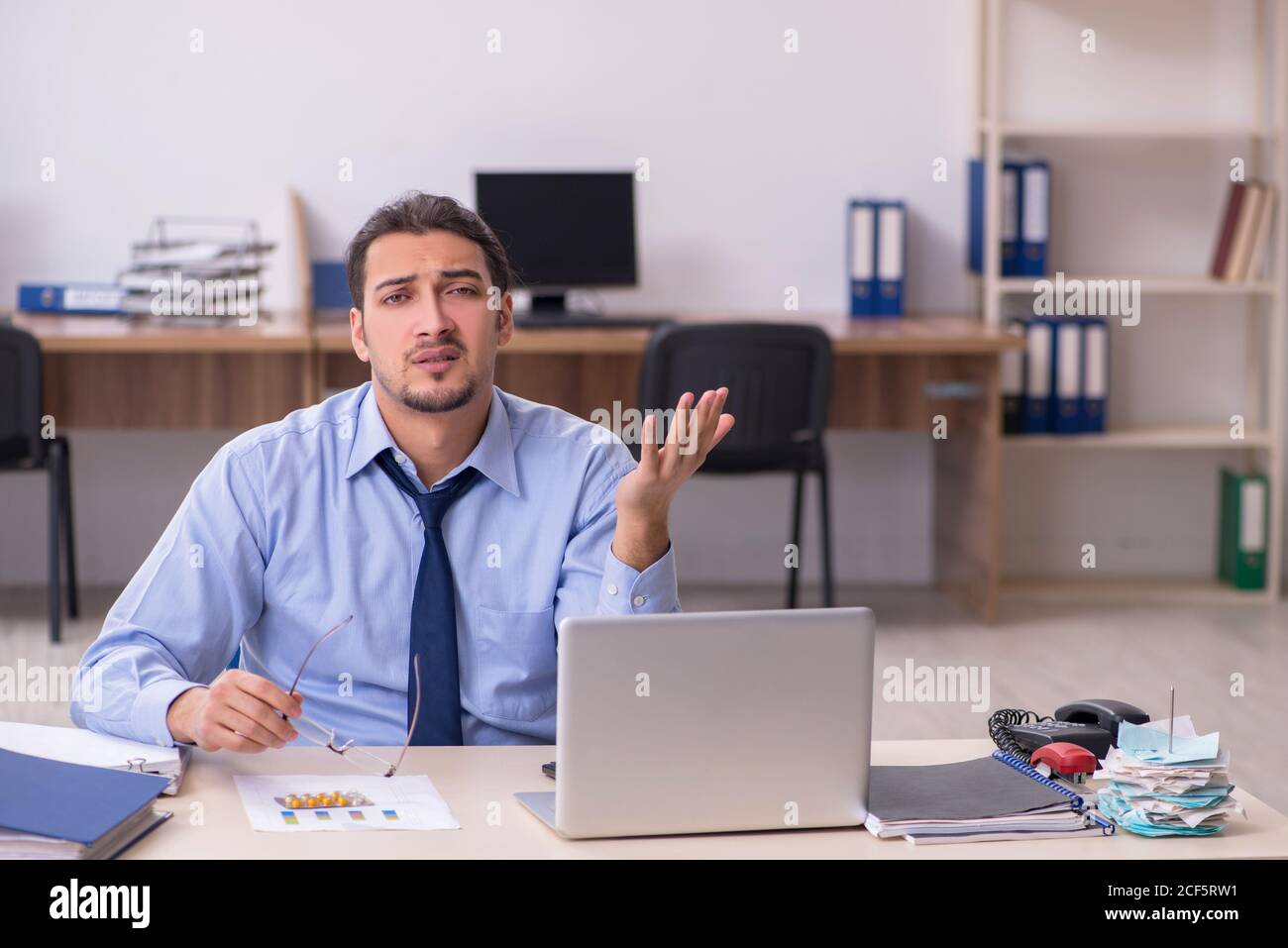 Sick male employee suffering at the workplace Stock Photo - Alamy