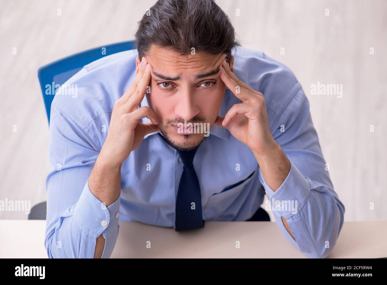 Sick male employee suffering at the workplace Stock Photo - Alamy