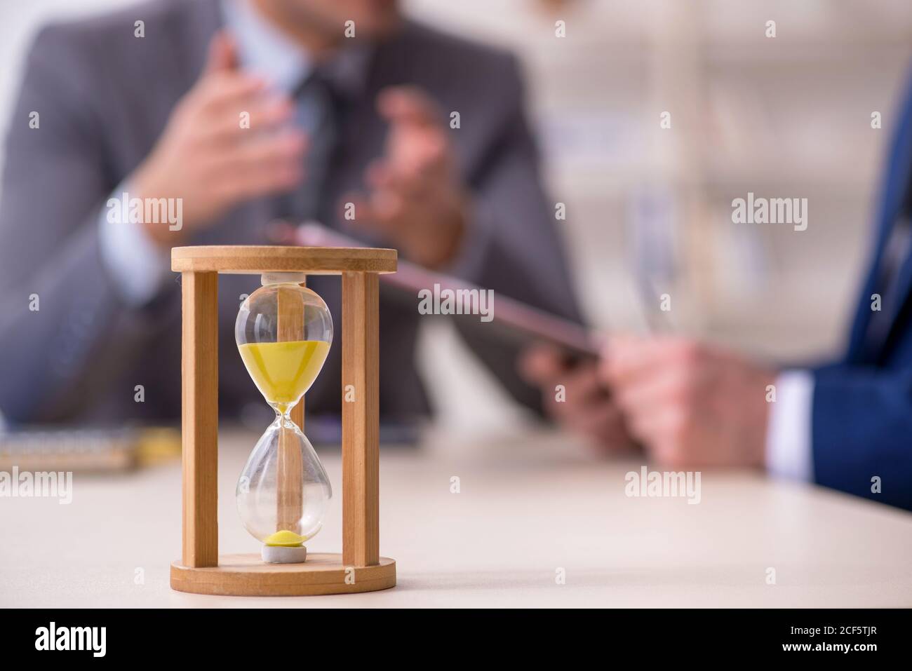 Two businessmen in the time management concept Stock Photo - Alamy