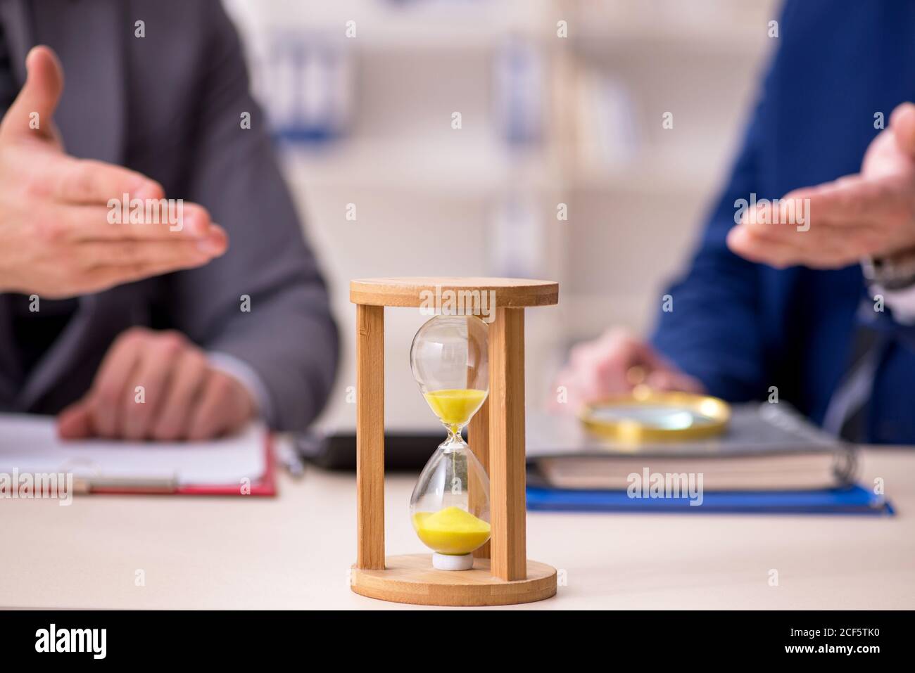 Two businessmen in the time management concept Stock Photo - Alamy