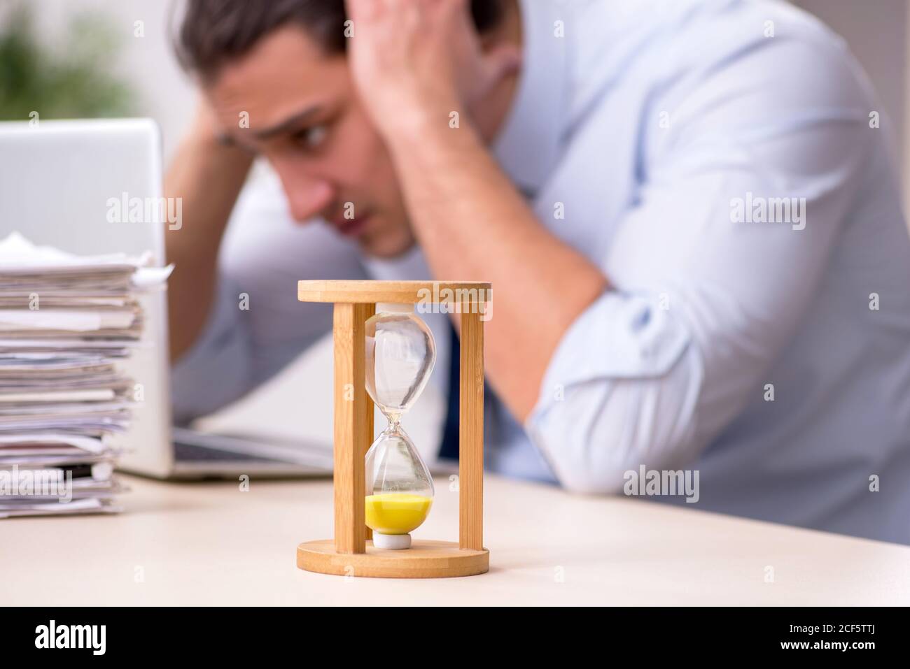 Young employee in time management concept Stock Photo - Alamy