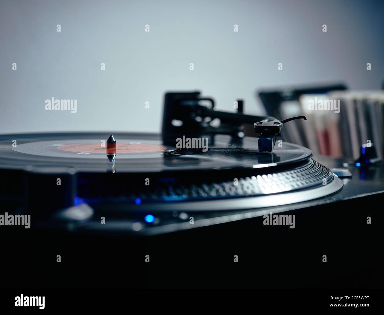 Closeup of top of old black turntable with tonearm maintaining position ...