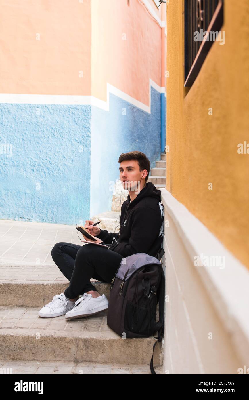 Male student making notes on street Stock Photo - Alamy