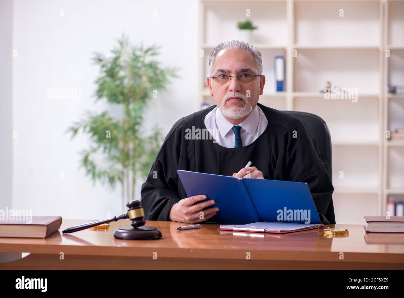 Old male judge working in the courthouse Stock Photo - Alamy