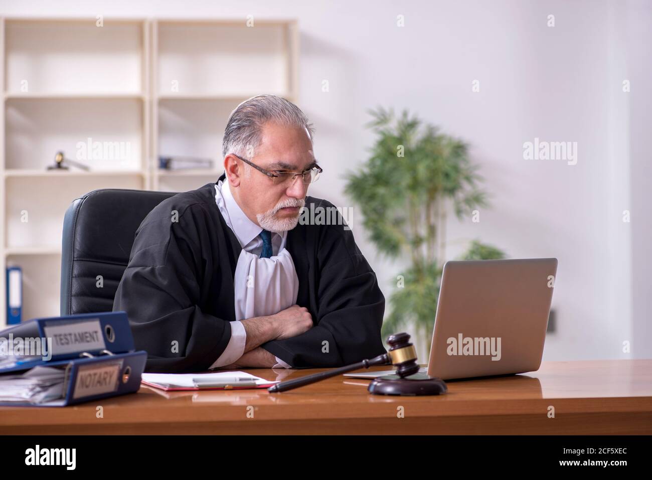 Old male judge working in the courthouse Stock Photo - Alamy