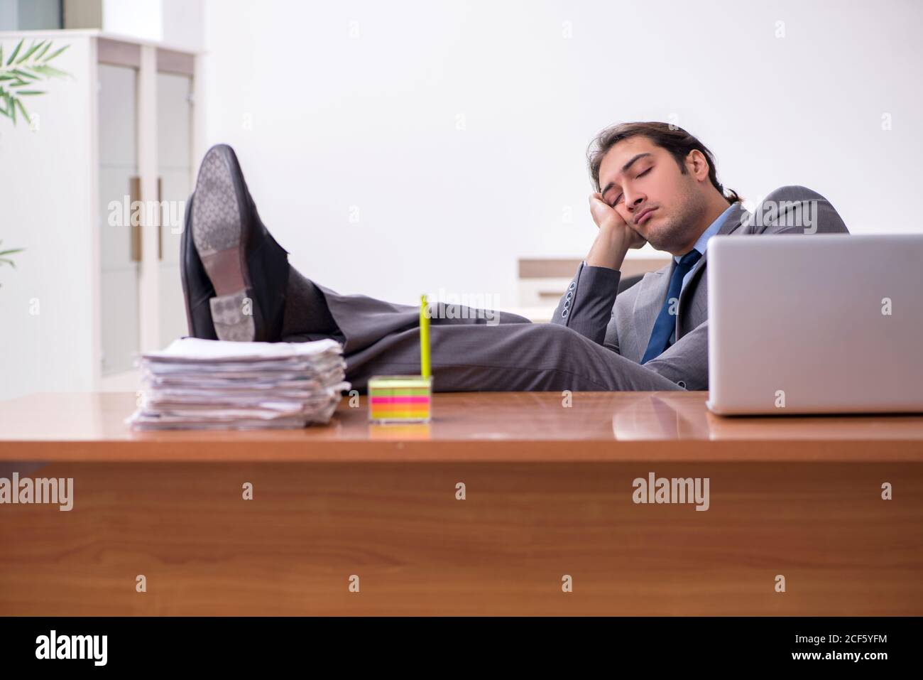 Young employee sleeping in the office Stock Photo - Alamy