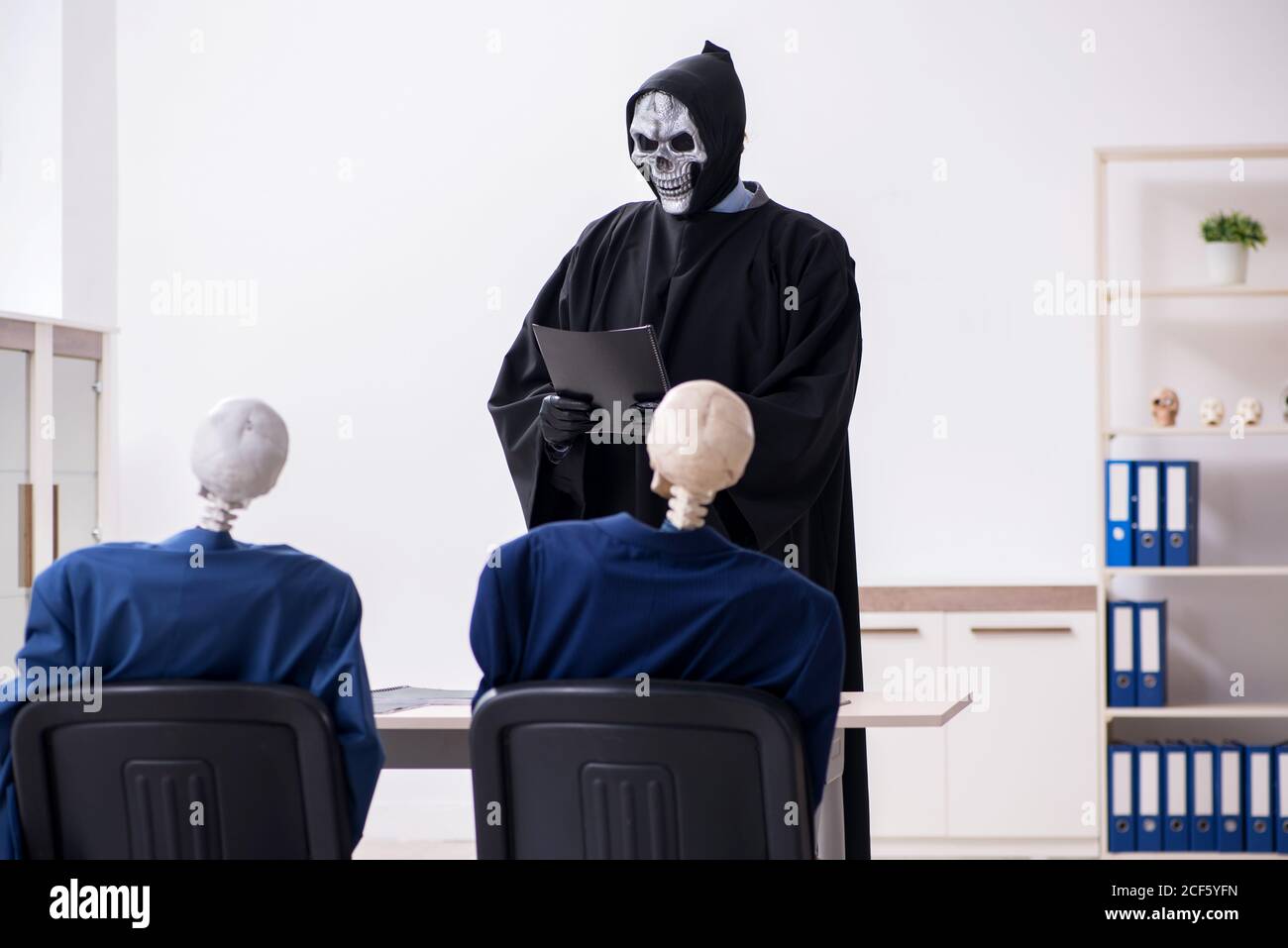 Funny business meeting with the devil and skeletons Stock Photo - Alamy