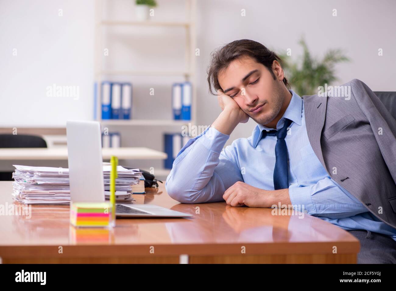 Young employee sleeping in the office Stock Photo - Alamy