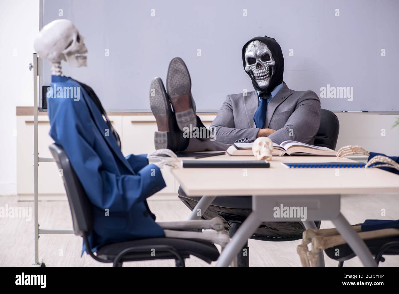 Funny business meeting with the devil and skeletons Stock Photo - Alamy