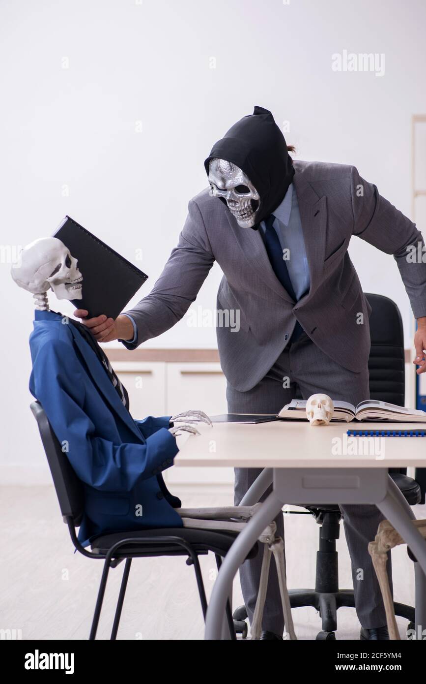 Funny business meeting with the devil and skeletons Stock Photo - Alamy