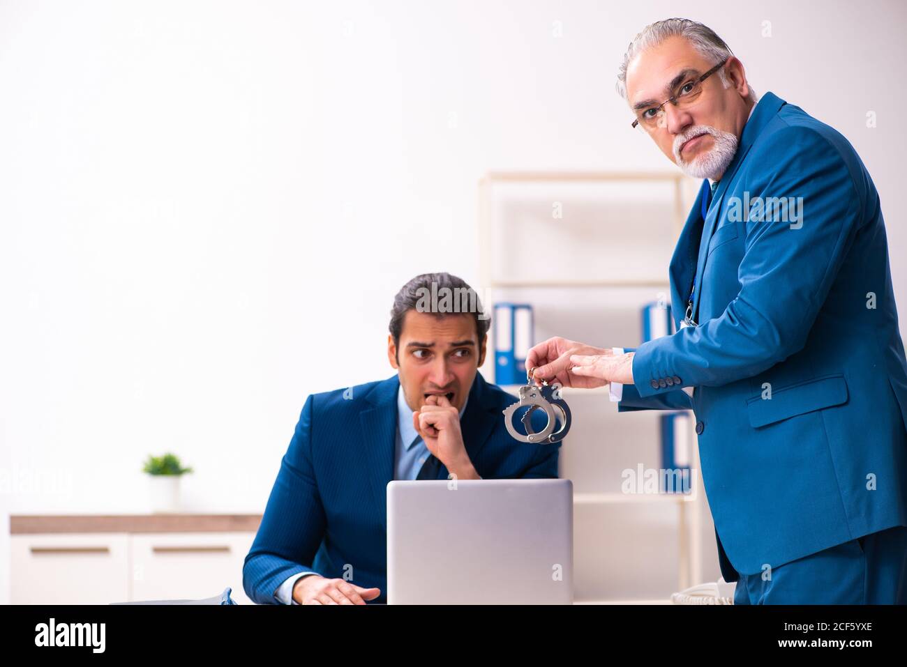 Male employee and cop in police investigation Stock Photo - Alamy