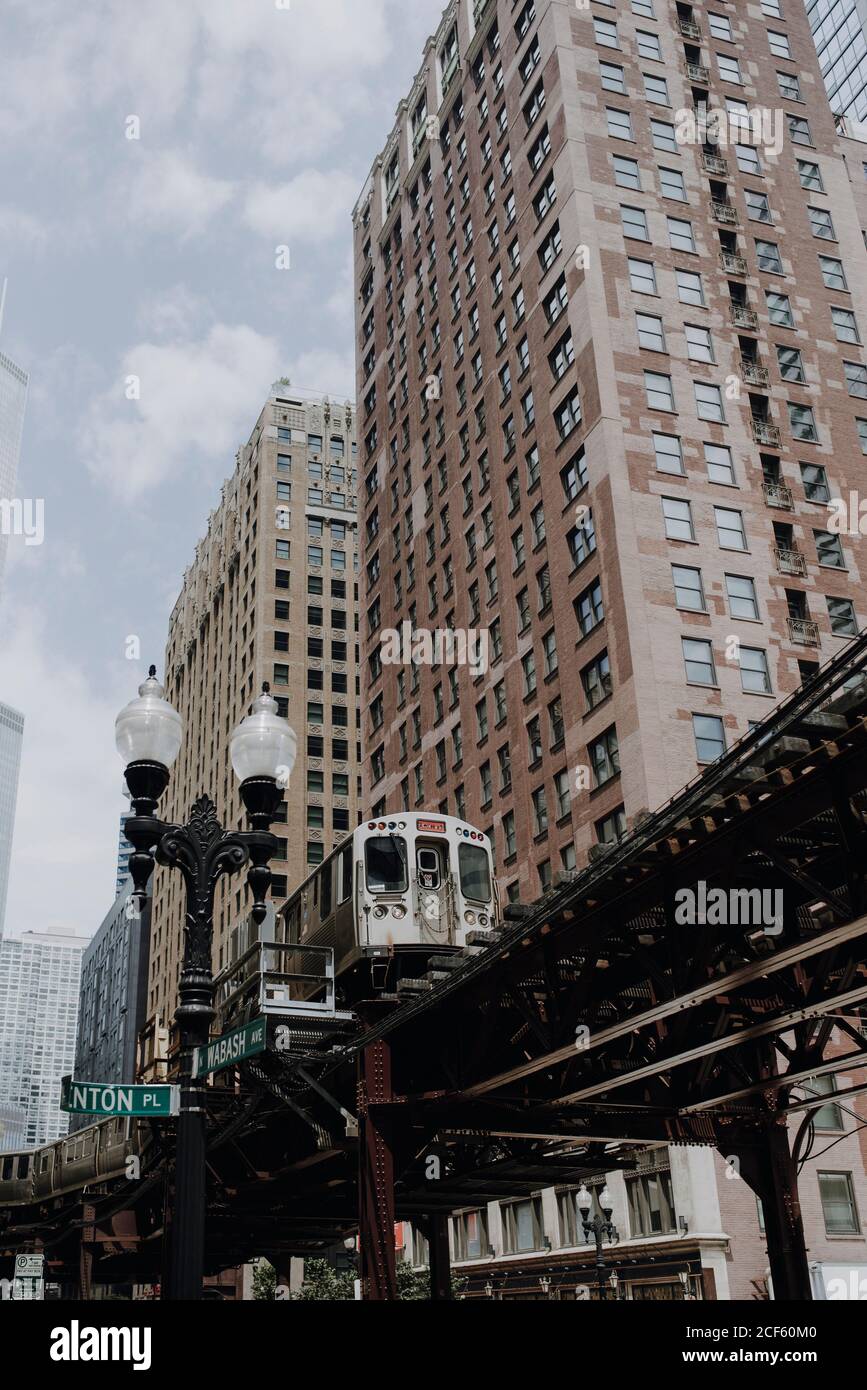 Low angle of street of Chicago city with commuter train going on ...