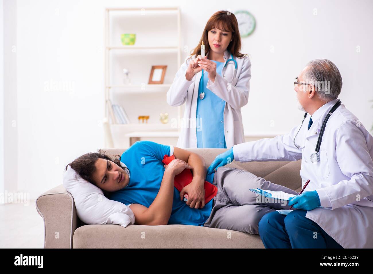 Two doctors visiting sick man at home Stock Photo - Alamy