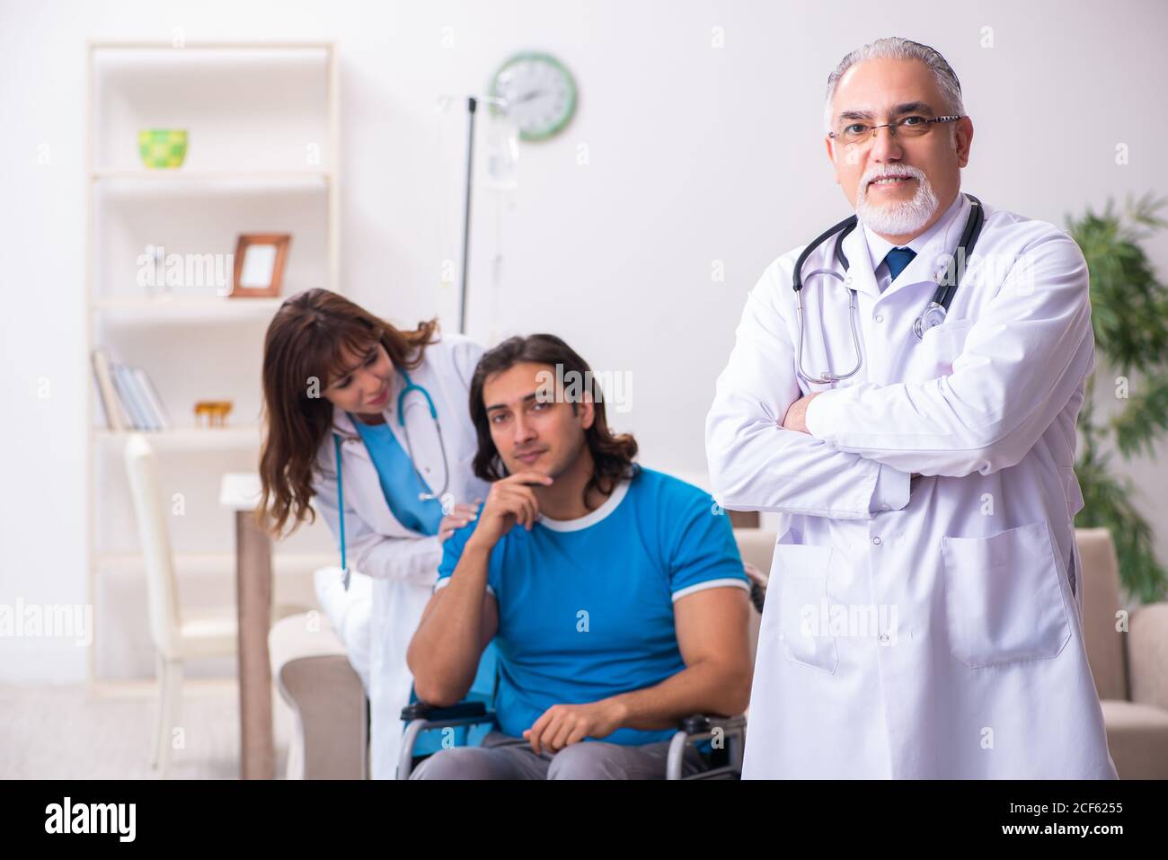 Two doctors visiting sick man at home Stock Photo - Alamy