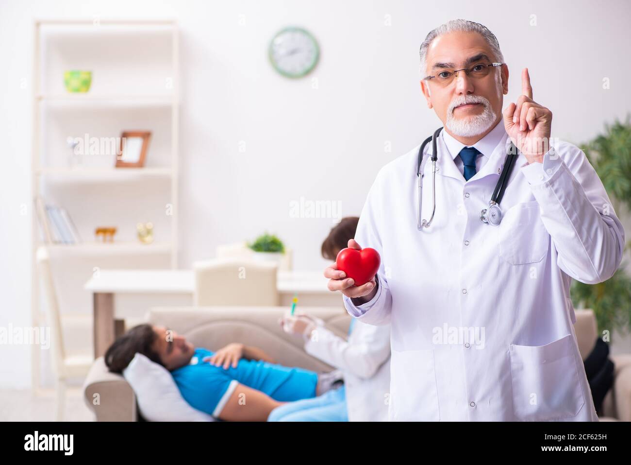 Two doctors visiting sick man at home Stock Photo - Alamy