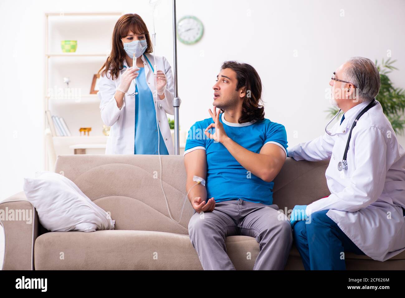 Two doctors visiting sick man at home Stock Photo - Alamy