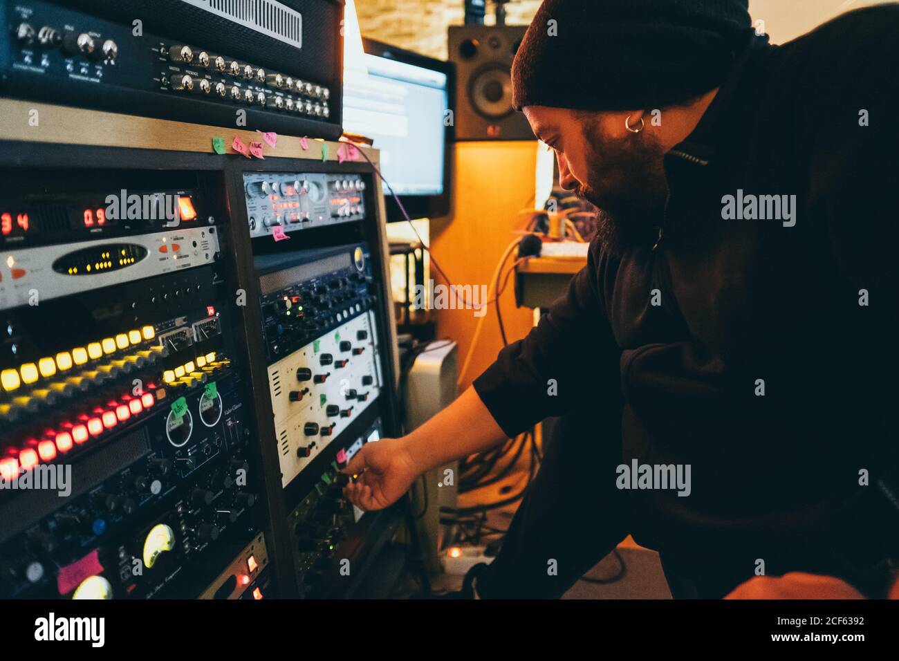 man musician working while adjusting music stereo control in a studio ...